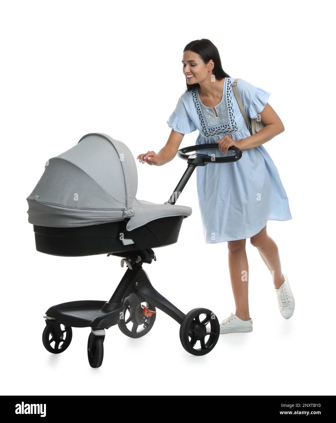 Happy young woman with baby stroller on white background Stock Photo ...