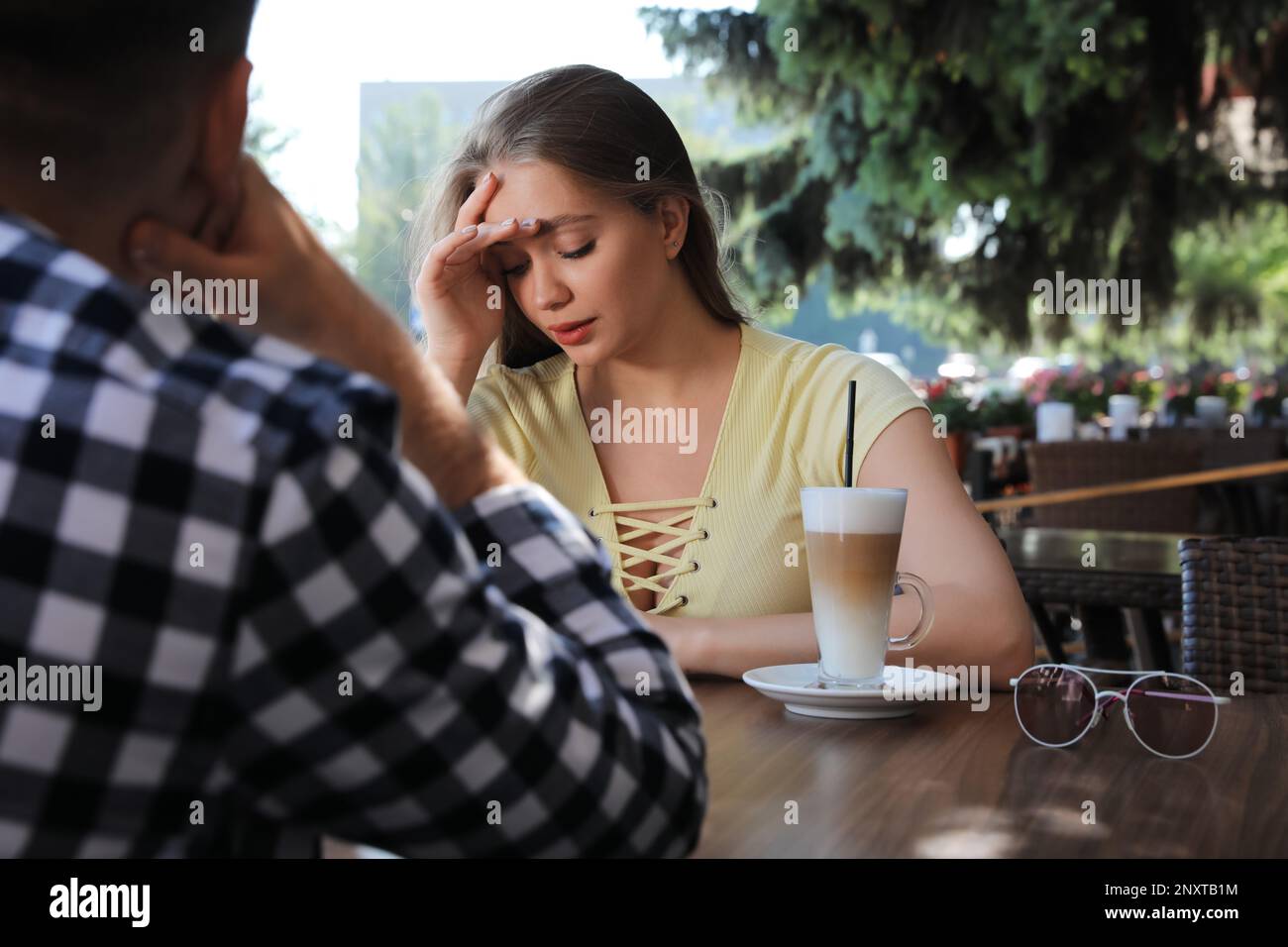 Young woman having boring date with guy in outdoor cafe Stock Photo - Alamy
