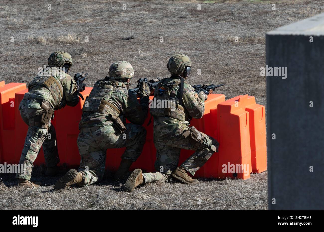 Airmen from the 22nd Security Forces Squadron kneel behind a barricade ...