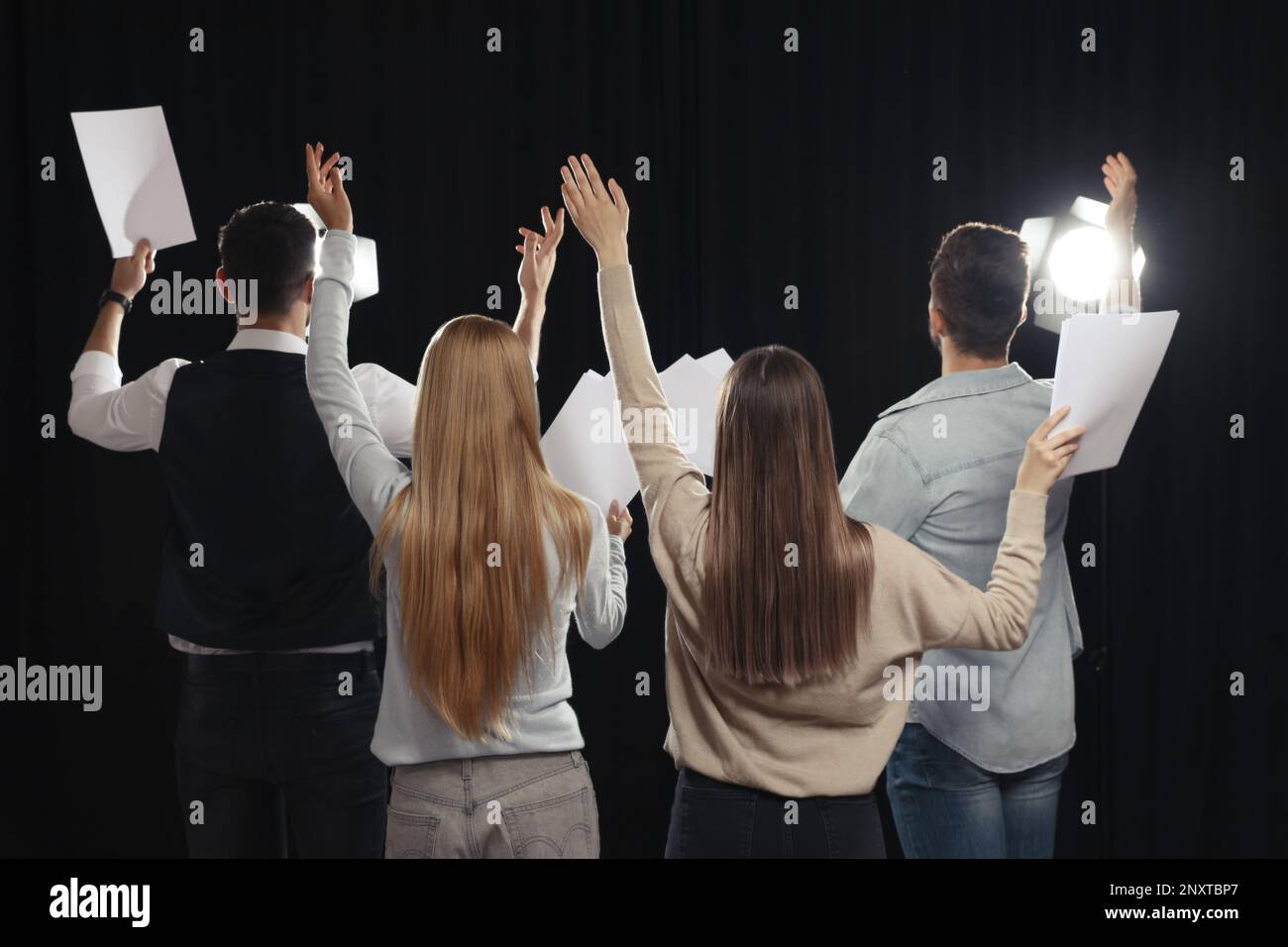 Professional actors bowing on stage in theatre, back view Stock Photo ...