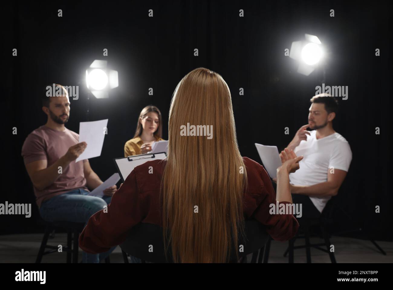 Professional actors reading their scripts during rehearsal in theatre ...