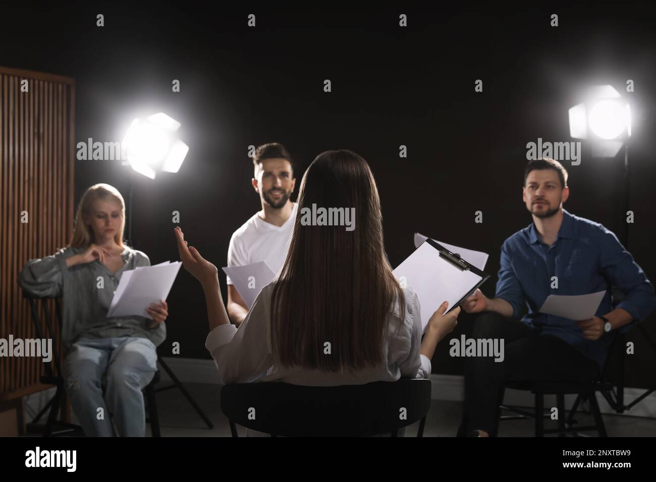 Professional actors reading their scripts during rehearsal in theatre ...