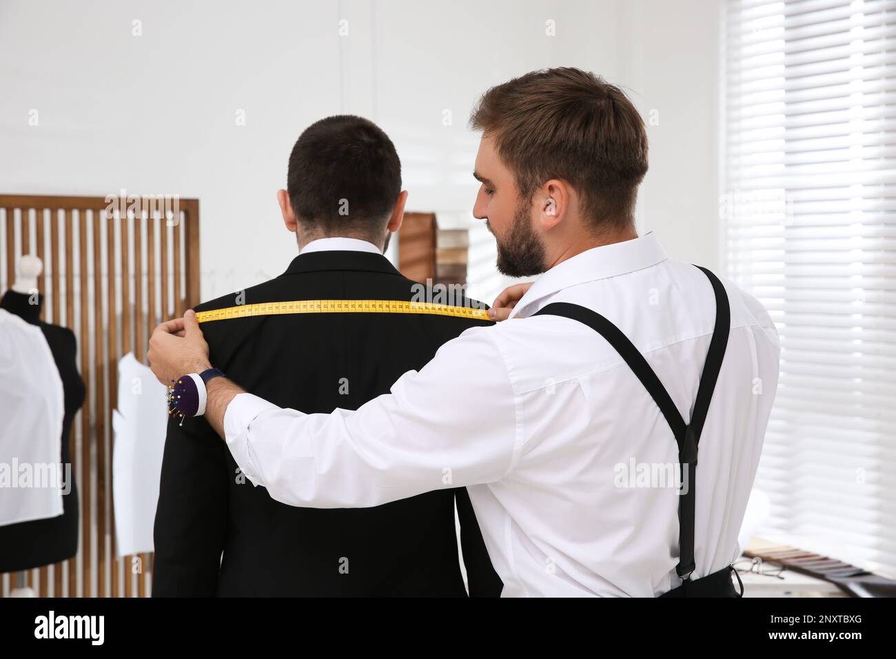 Professional tailor measuring client's shoulder width in atelier Stock ...