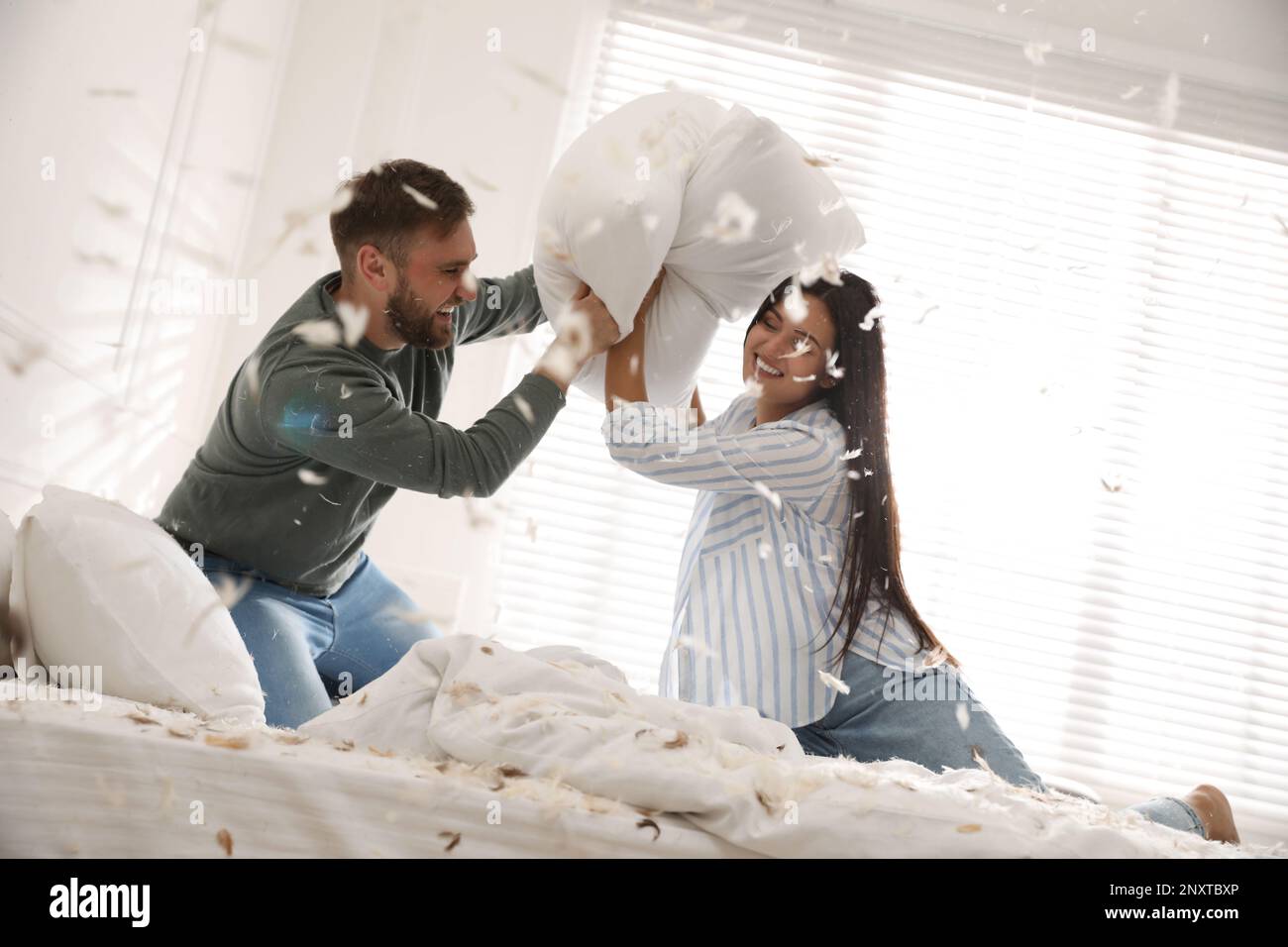 Happy young couple having fun pillow fight in bedroom Stock Photo - Alamy