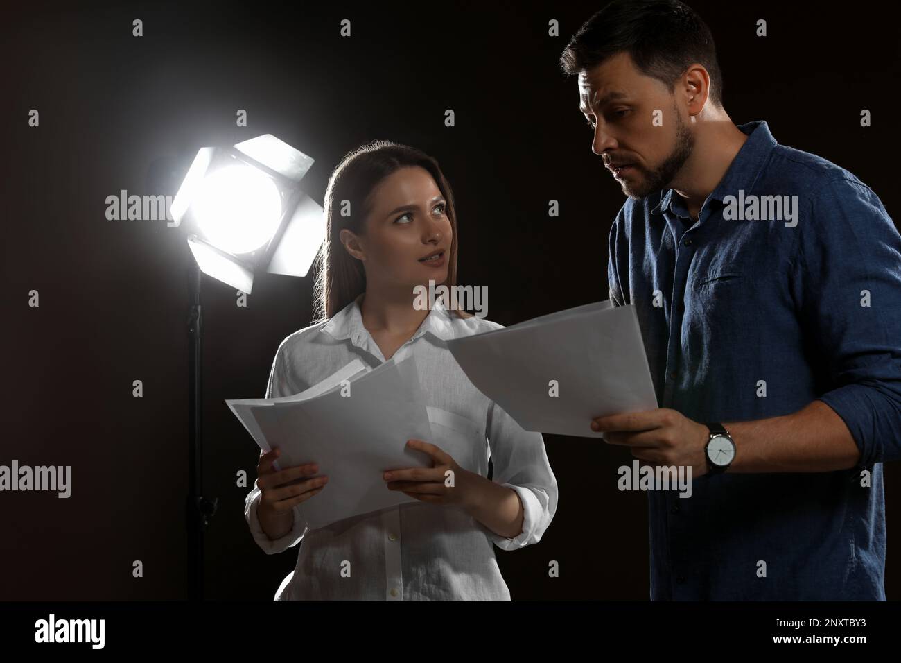 Professional actors reading their scripts during rehearsal in theatre ...