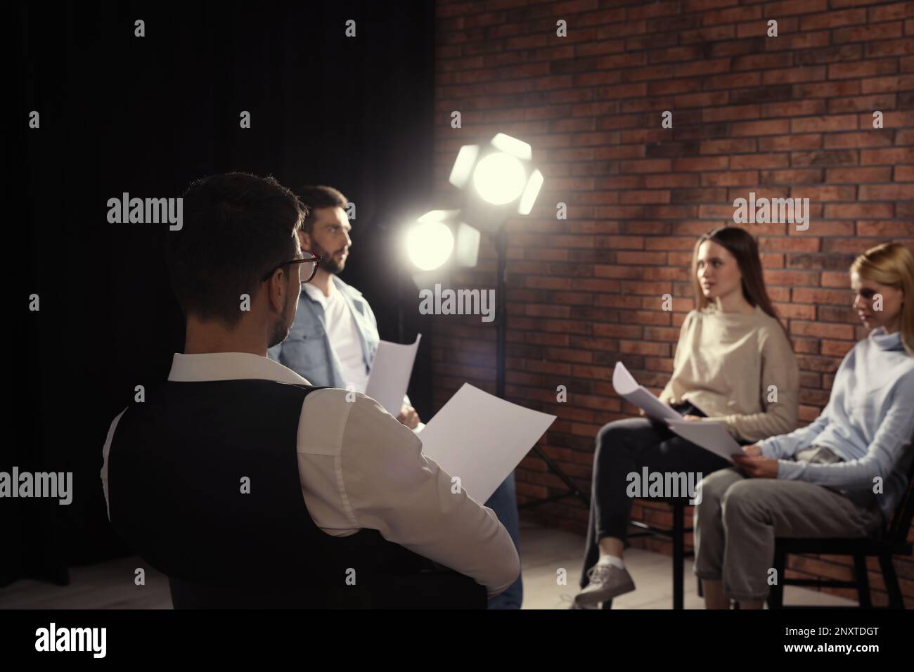 Professional actors reading their scripts during rehearsal in theatre ...
