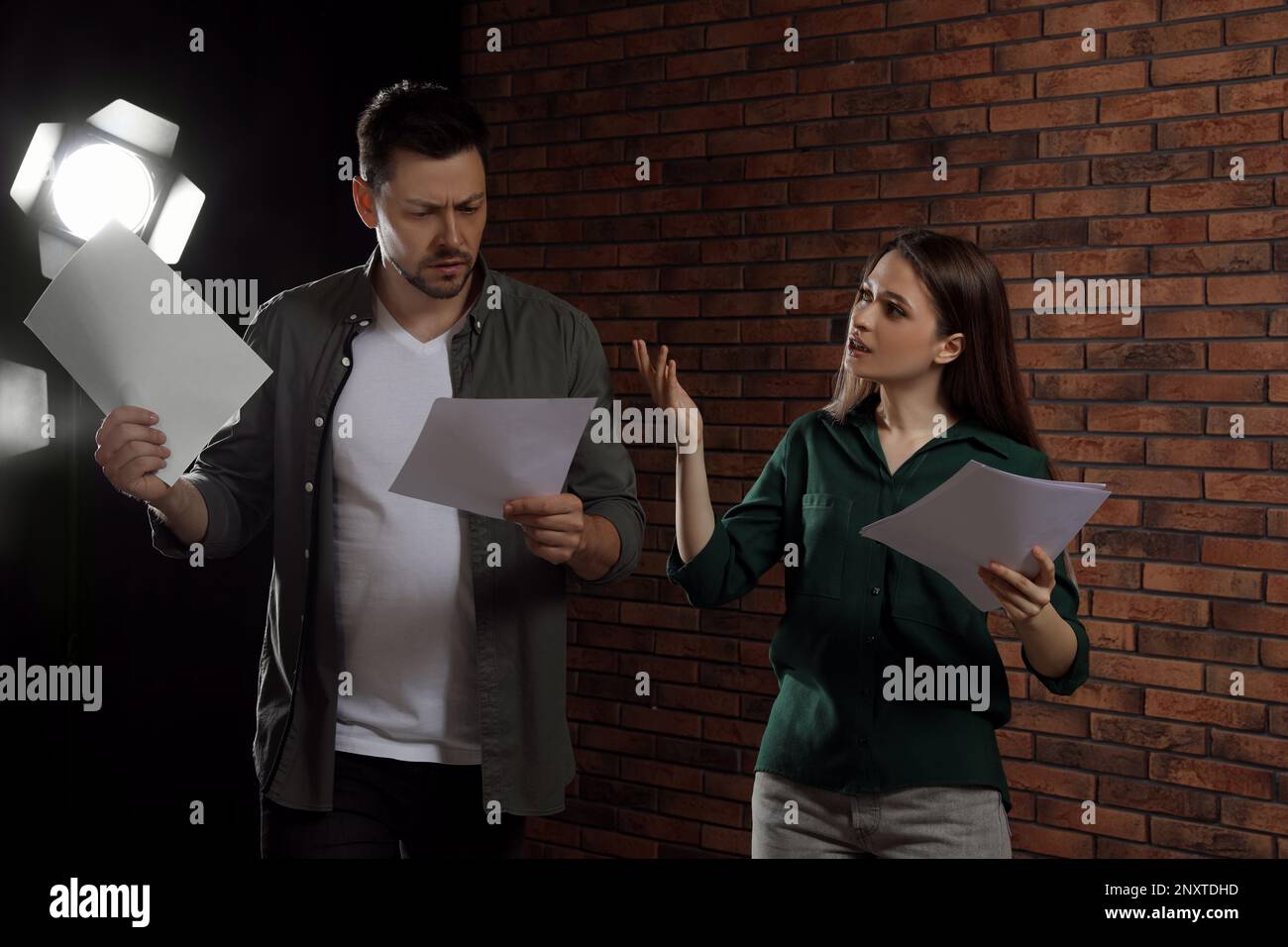 Professional actors reading their scripts during rehearsal in theatre ...