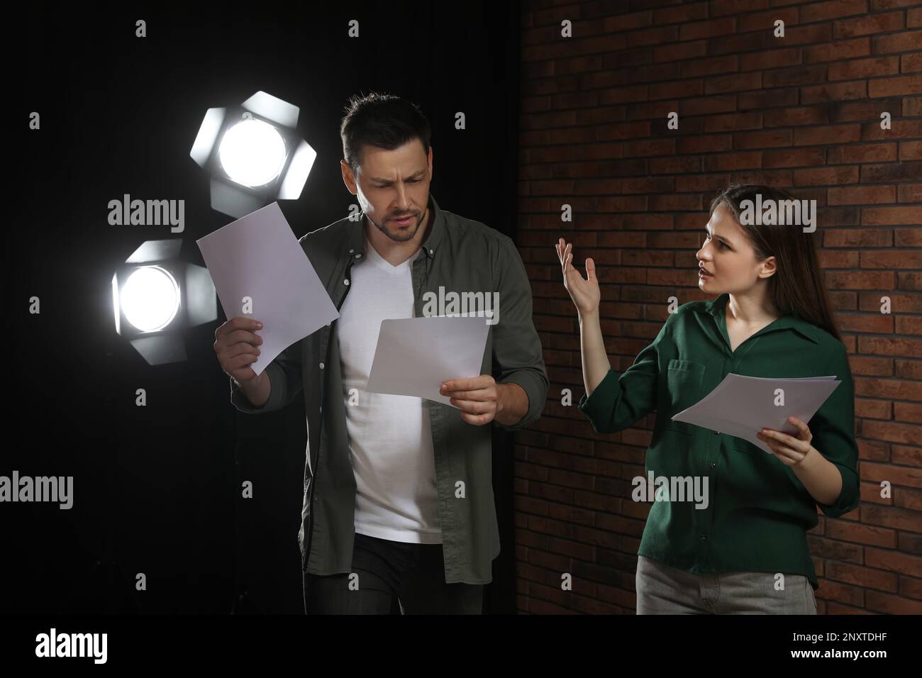 Professional actors reading their scripts during rehearsal in theatre ...