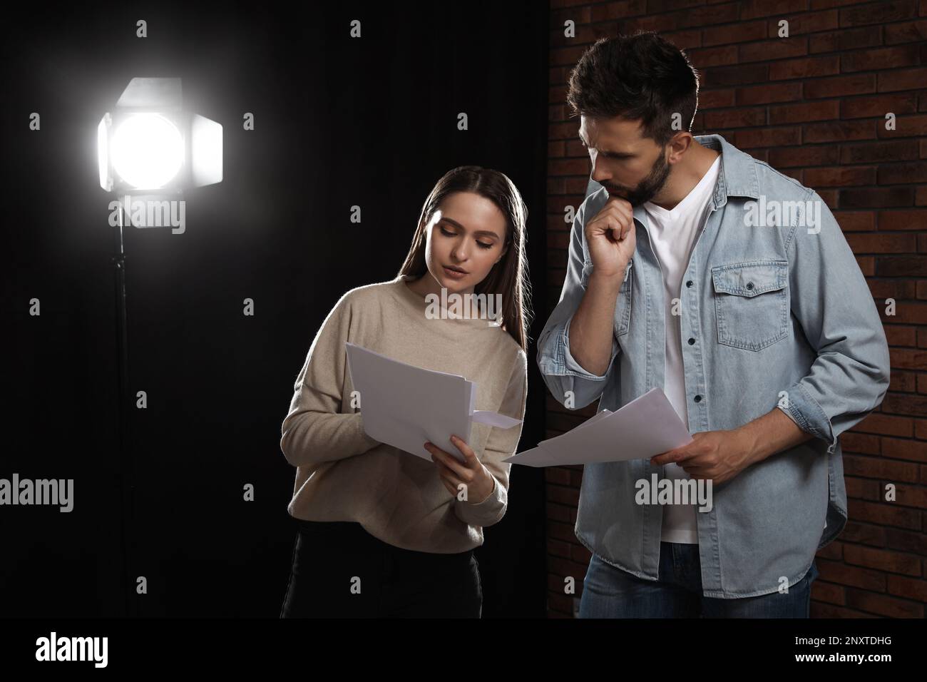 Professional actors reading their scripts during rehearsal in theatre ...