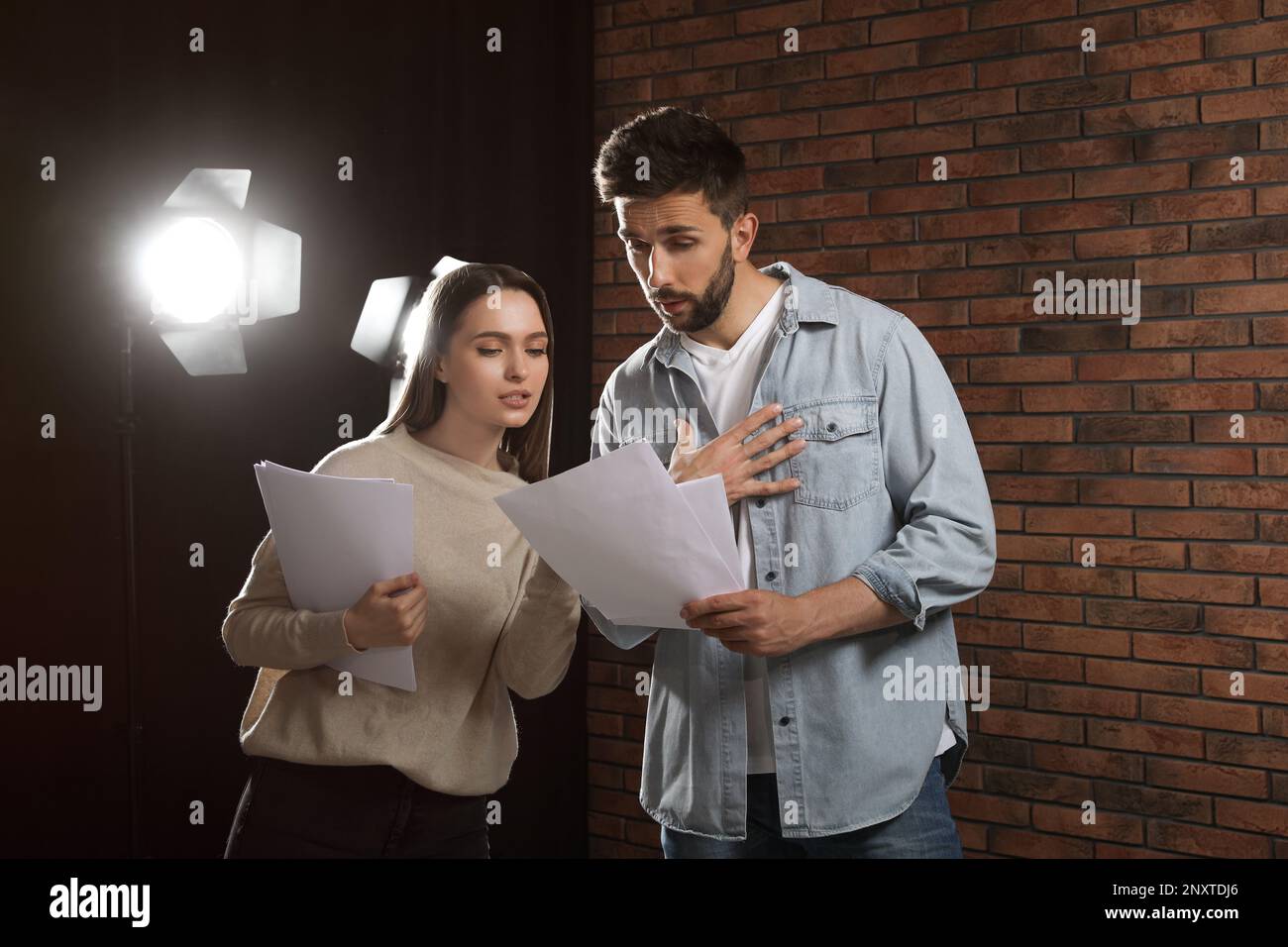 Professional actors reading their scripts during rehearsal in theatre ...