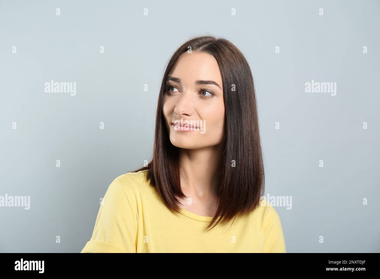 Portrait of pretty young woman with gorgeous chestnut hair on light ...
