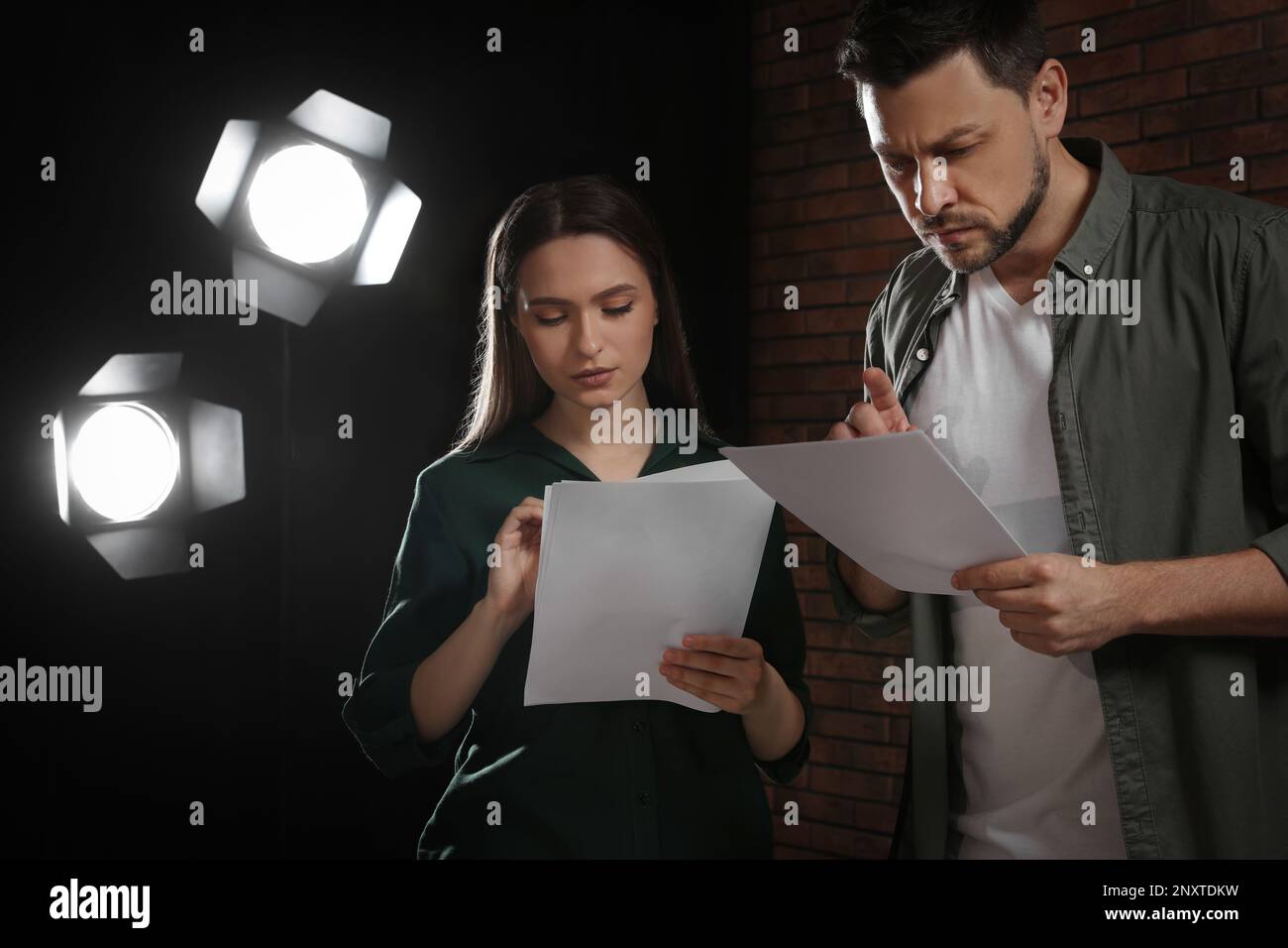 Professional actors reading their scripts during rehearsal in theatre ...