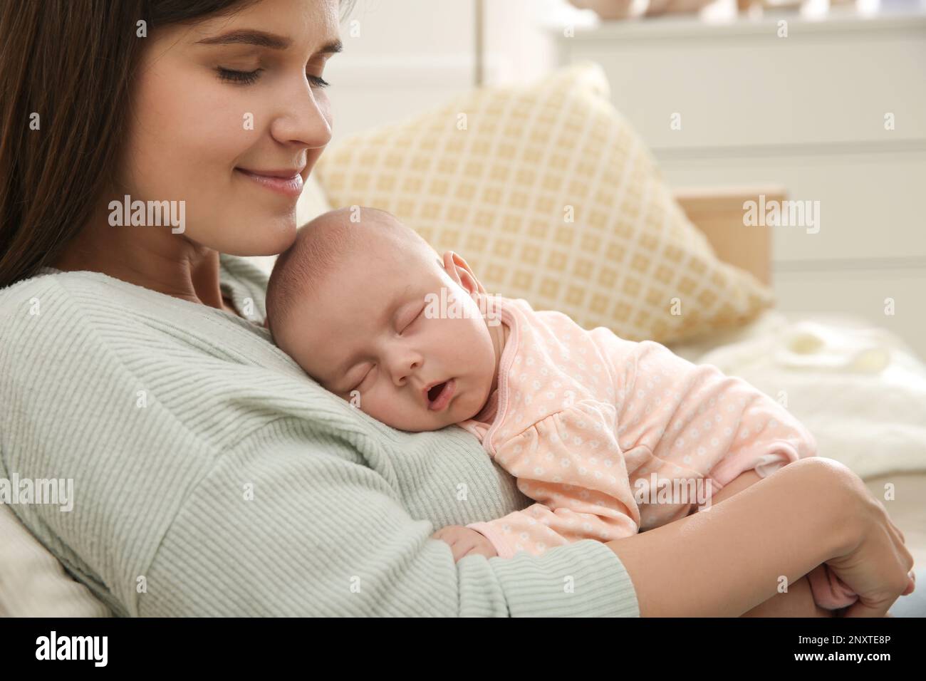 Mother holding her sleeping baby at home Stock Photo - Alamy
