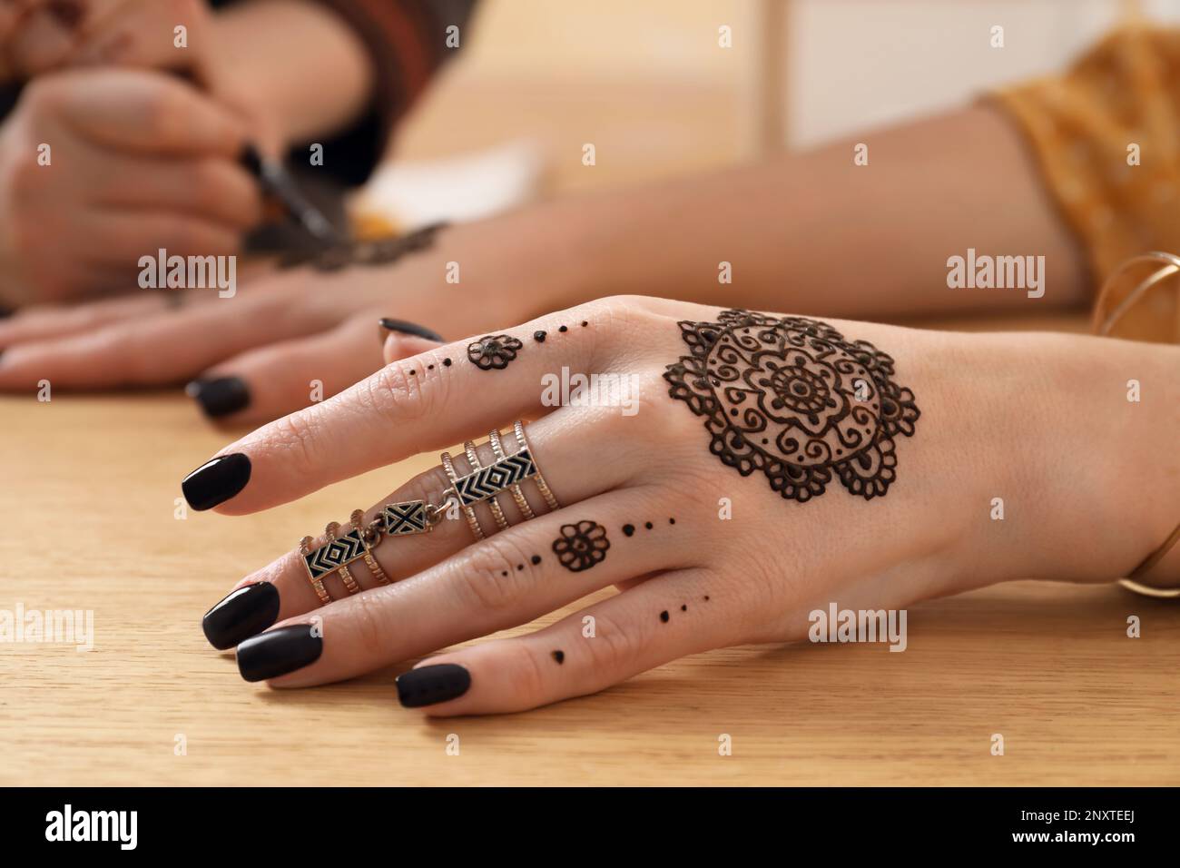 Professional mehndi master making henna tattoo at table, closeup Stock ...