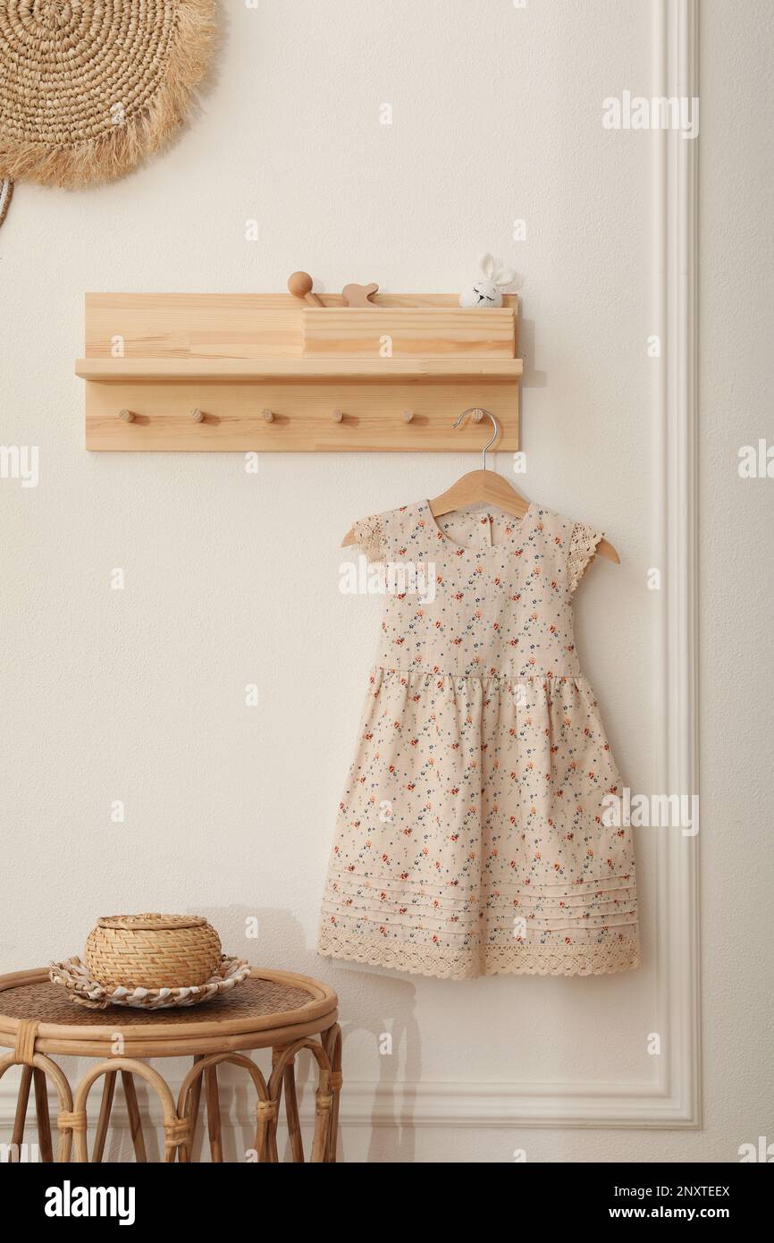 Wooden rack with cute dress in child room. Interior design Stock Photo ...