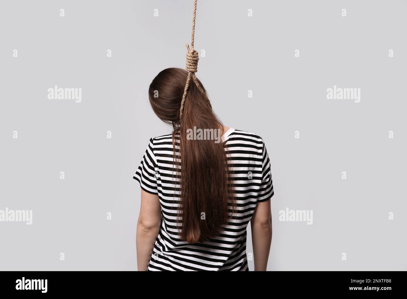 Woman with rope noose on neck against light grey background, back view ...