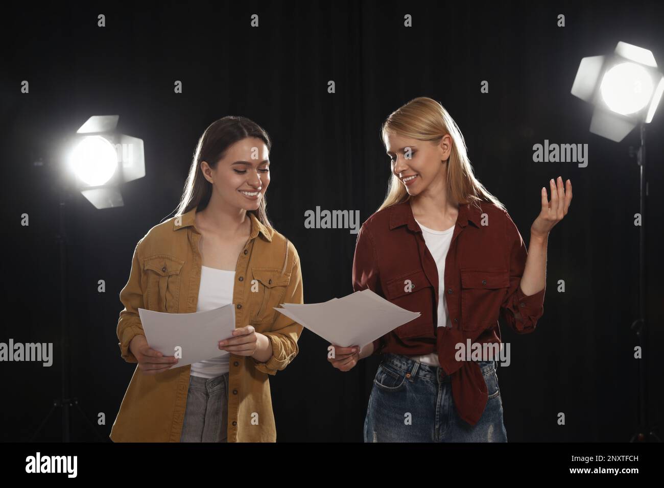 Professional actresses reading their scripts during rehearsal in ...