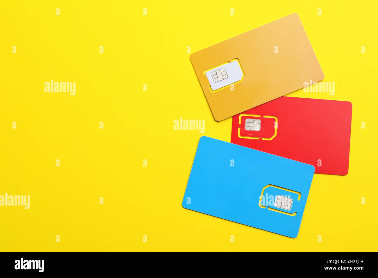 Different SIM cards on yellow background, flat lay. Space for text ...