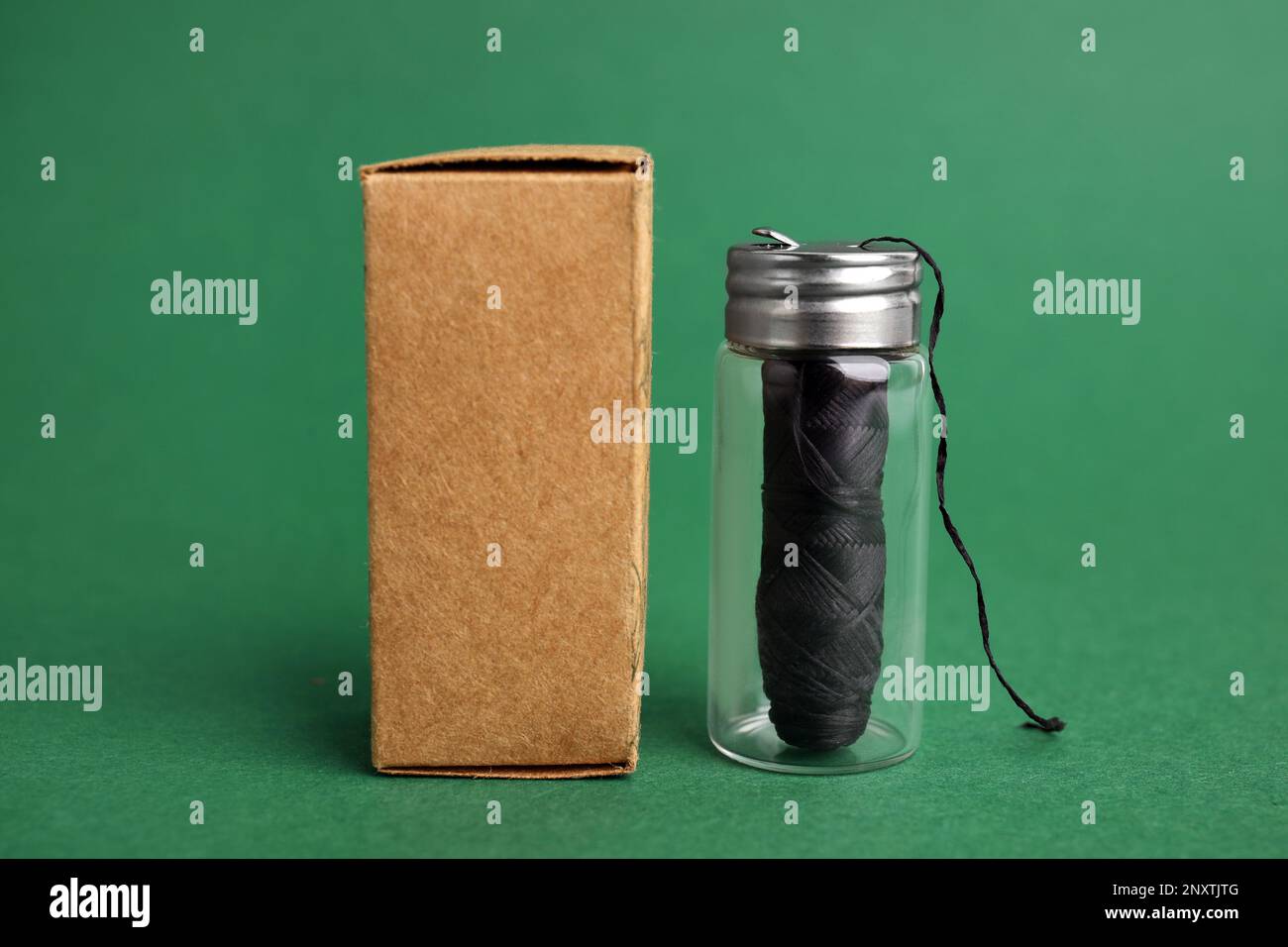 Biodegradable dental floss and cardboard package on dark green ...