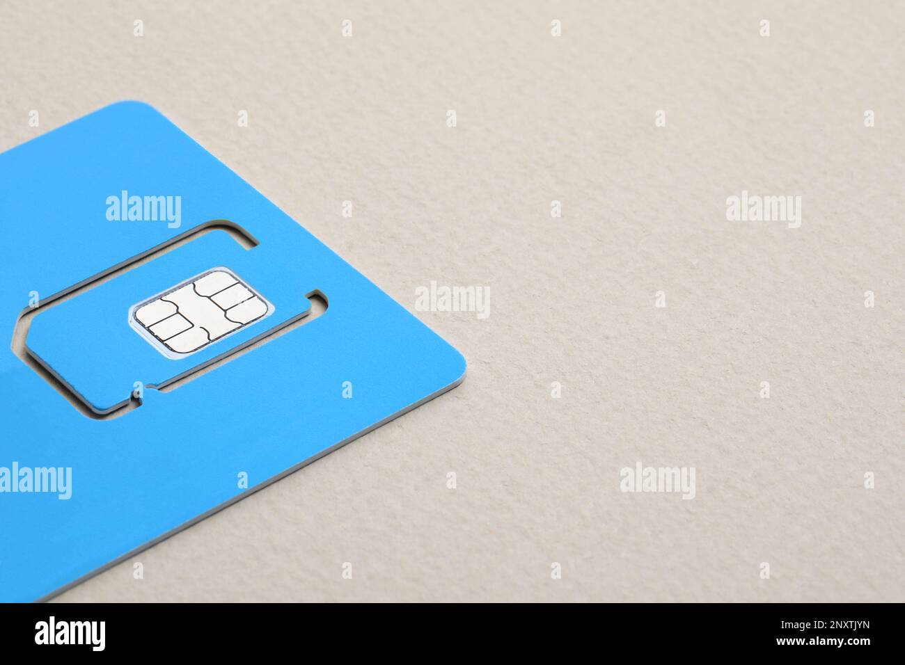 Light blue SIM card on beige background, closeup. space for text Stock ...