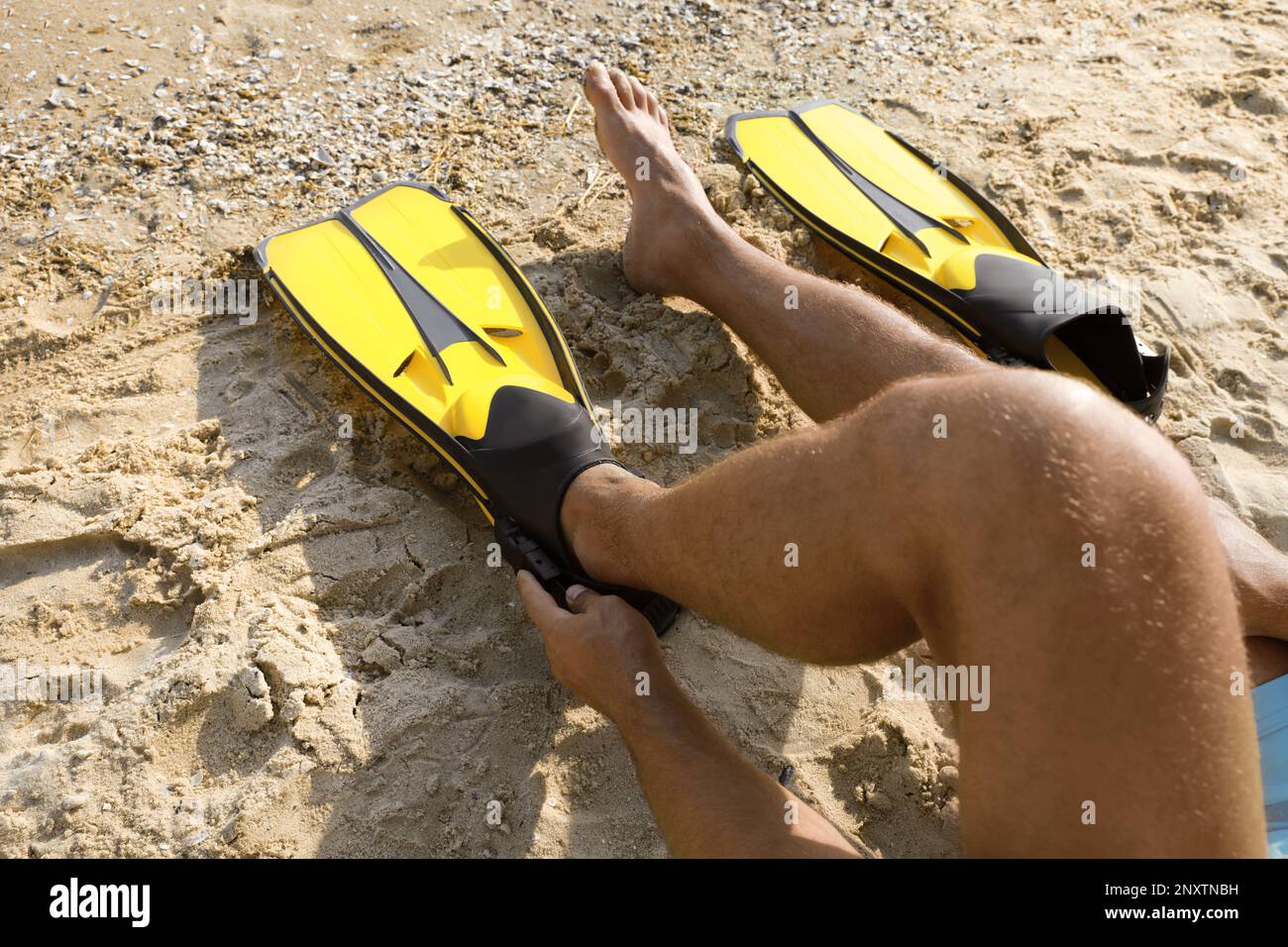Man wearing flippers on beach, closeup view Stock Photo - Alamy