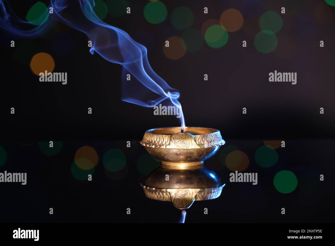 Blown out diya on dark background with blurred lights. Diwali lamp ...