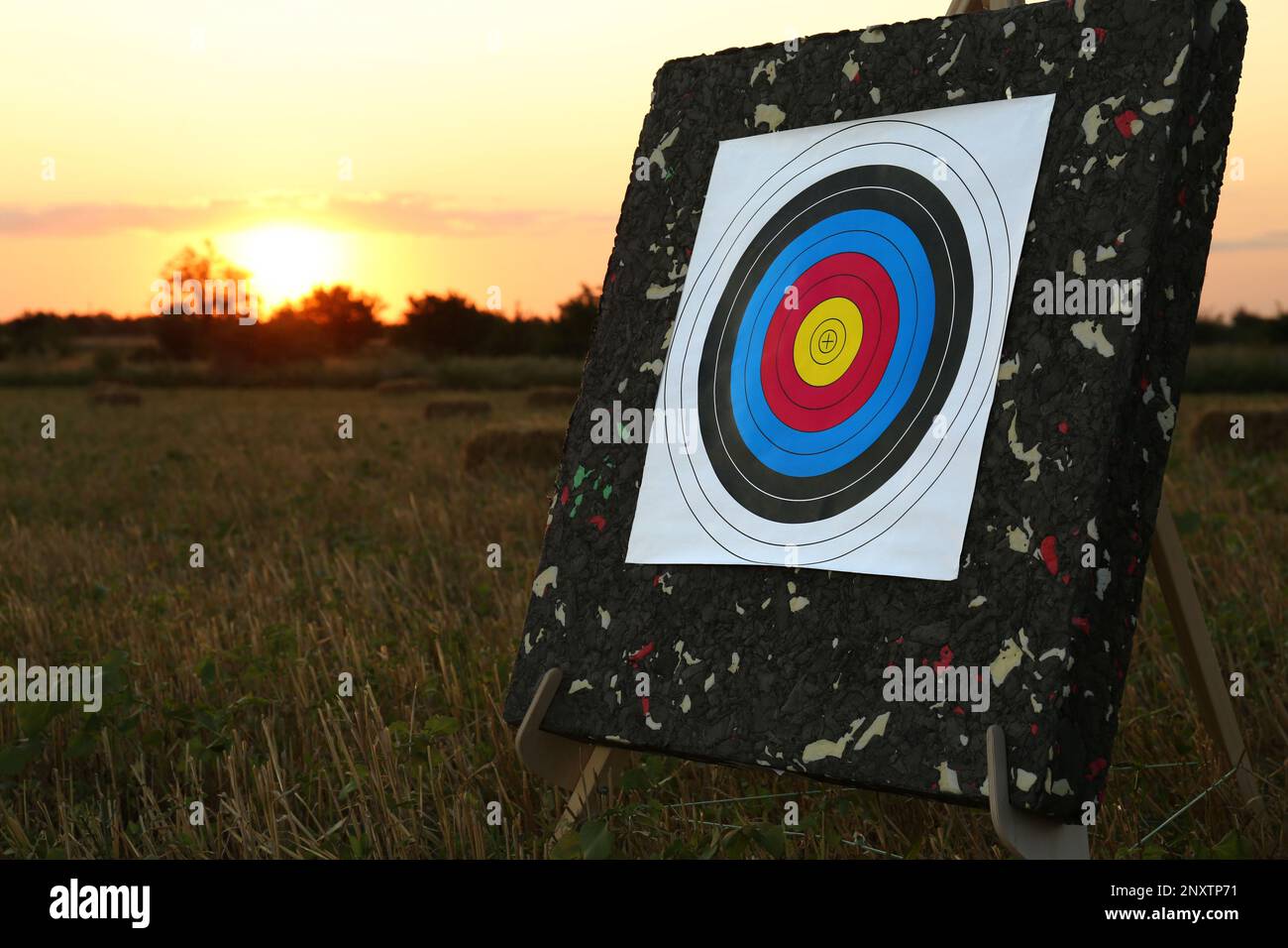 Tripod with archery target in field at sunset Stock Photo - Alamy