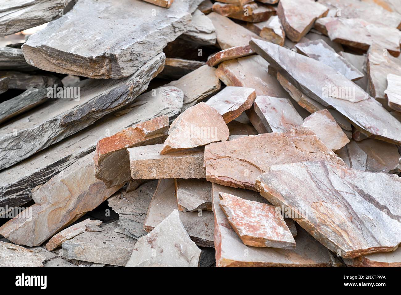 Heap of natural brown stone fragments for facing walls and laying paths ...