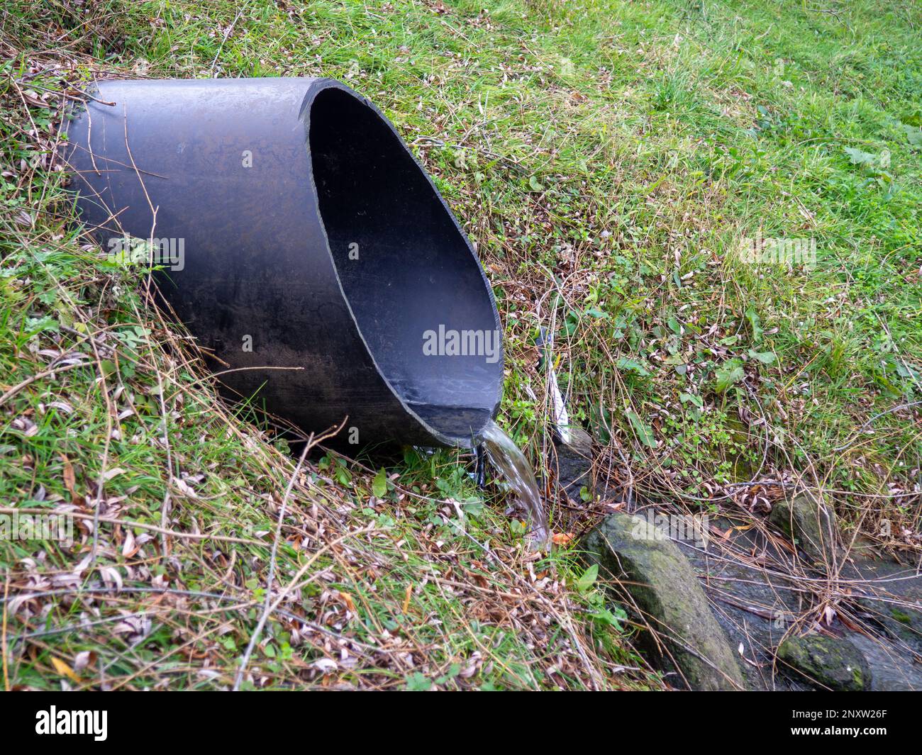 Water pours out of a large rubber pipe. Storm sewer system. Drainage of ...