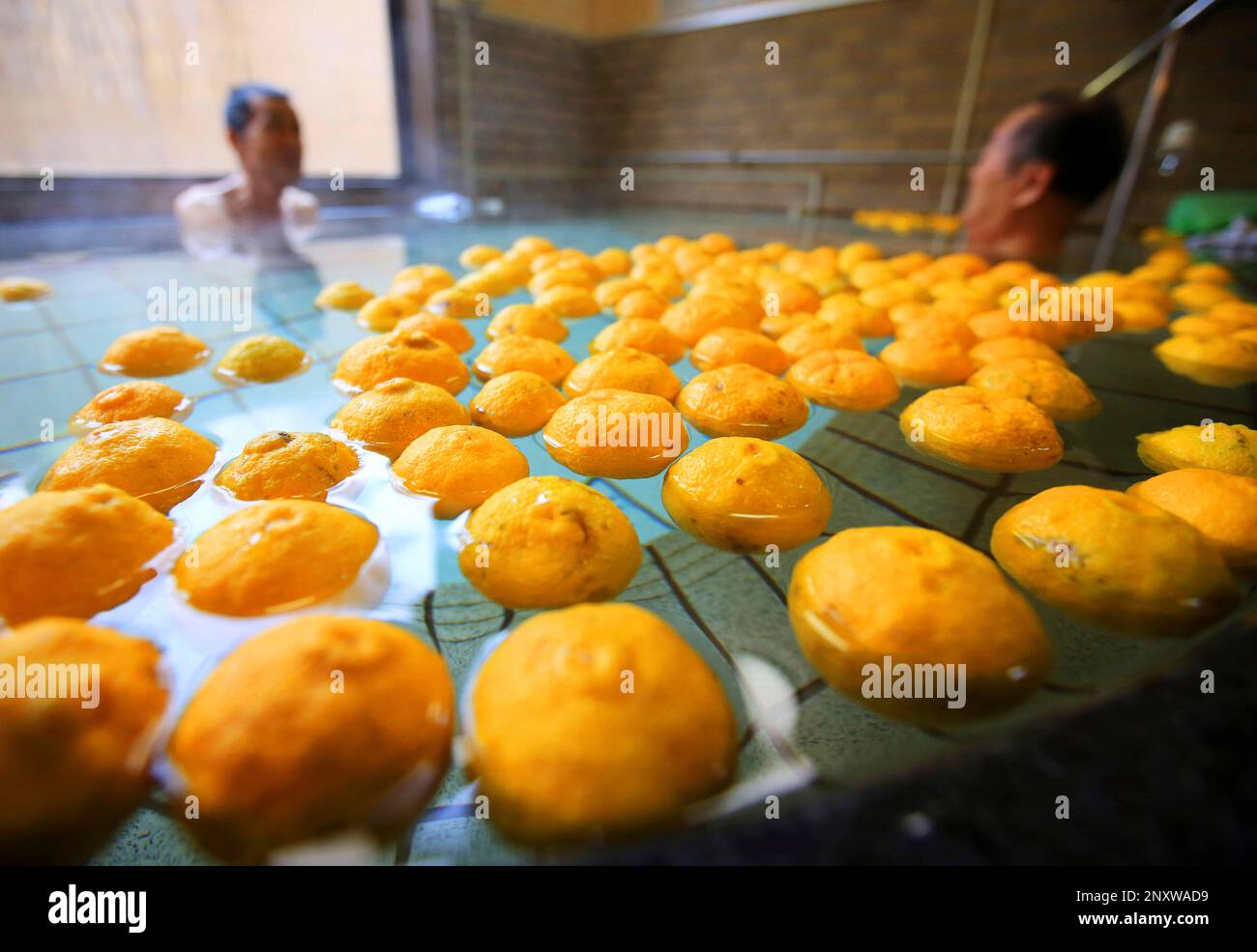 Two men take a Chinese lemon bath steeped with yuzu citrus (yuzu-yu in Japanese) at a hot spring ...