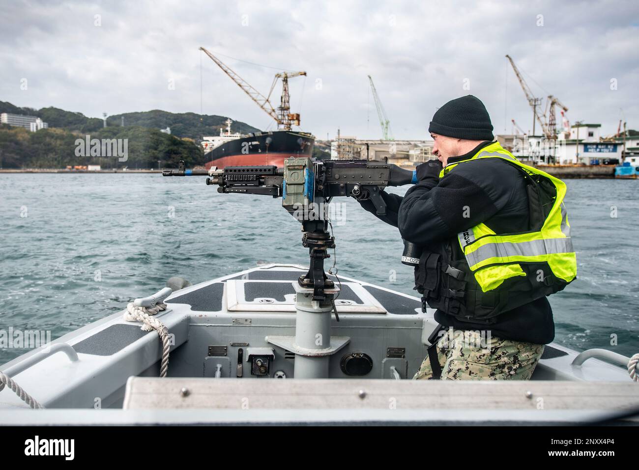 Master-at-Arms 2nd Class Mitchell Clark aims an M240B machine gun ...