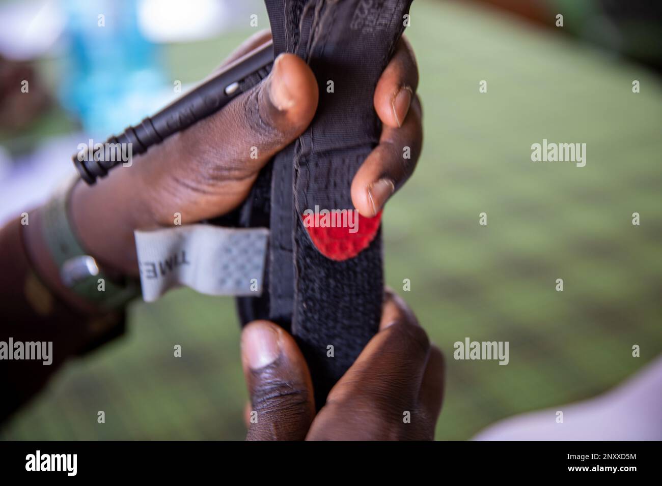 A Kenyan Defence Forces army medic adjusts a tourniquet during tactical ...