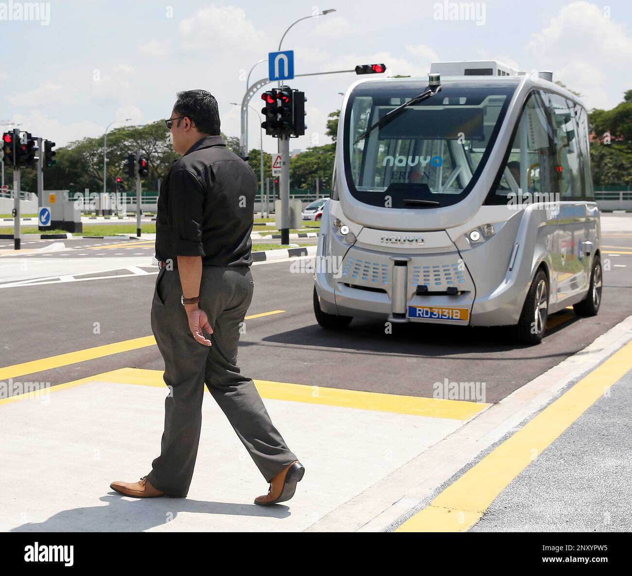 A "jay-walker" passes by the front of a Navya self-driving shuttle bus ...