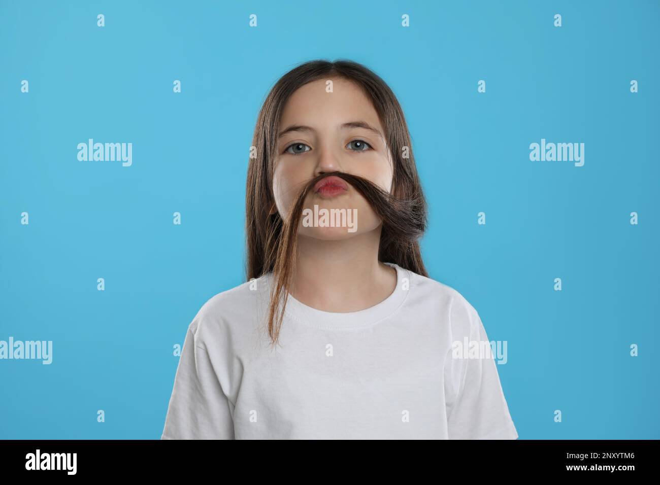 Cute little girl making fake mustache with her hair on turquoise background Stock Photo - Alamy