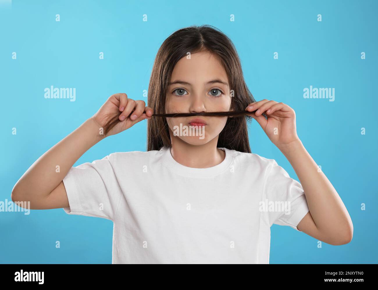 Cute little girl making fake mustache with her hair on turquoise background Stock Photo - Alamy