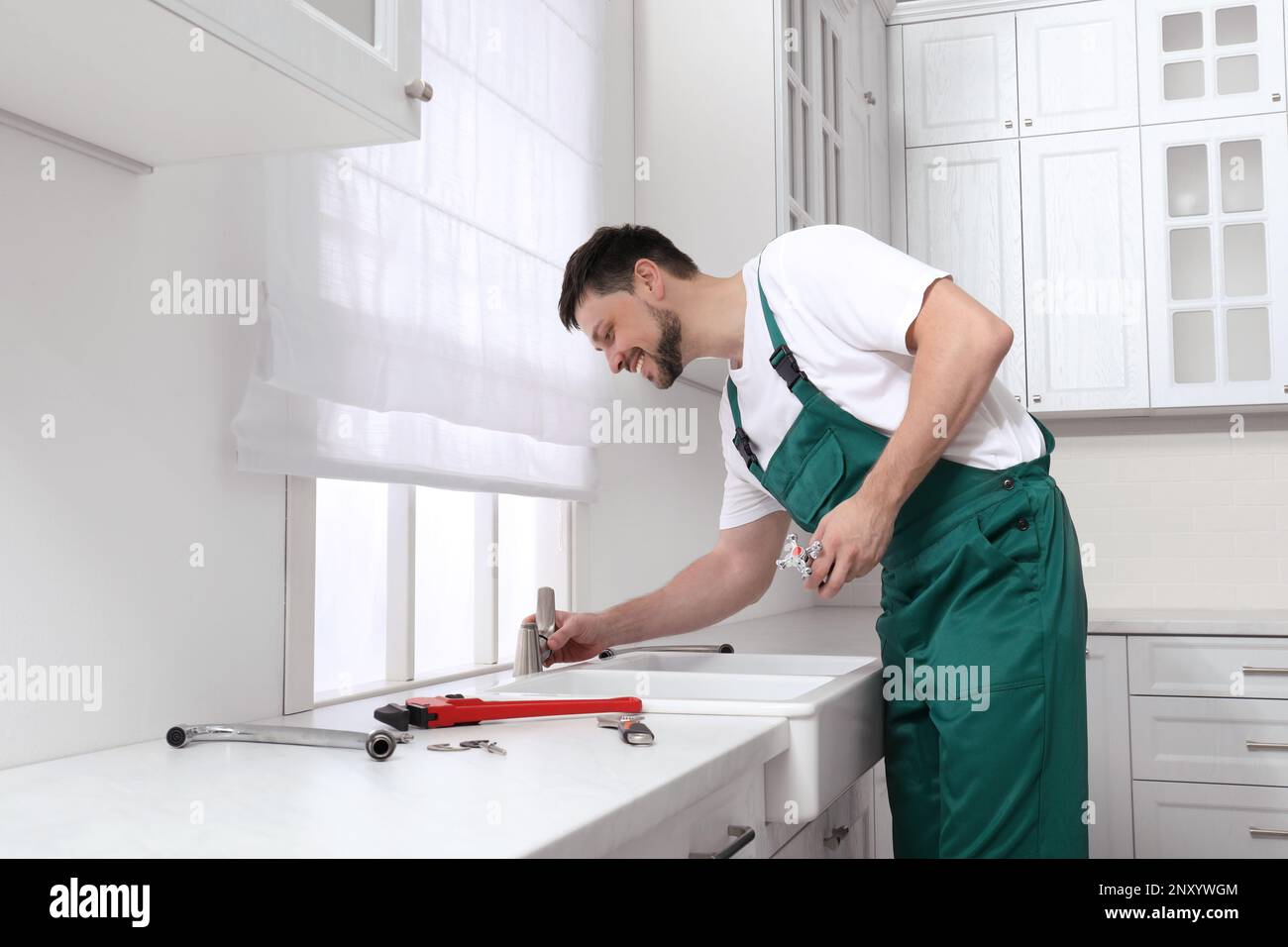 Handyman plumber fixing plumbing kitchen sink hi-res stock photography ...