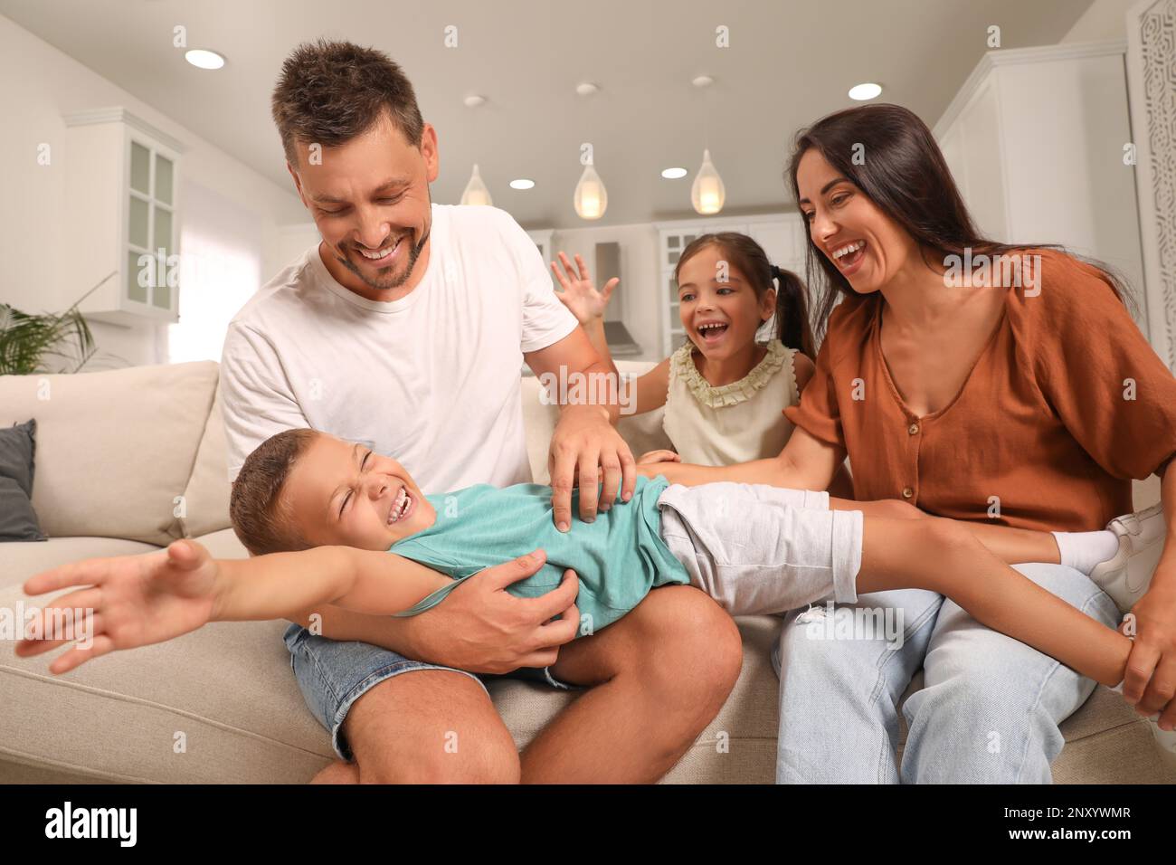 Happy family with children having fun on sofa at home Stock Photo - Alamy