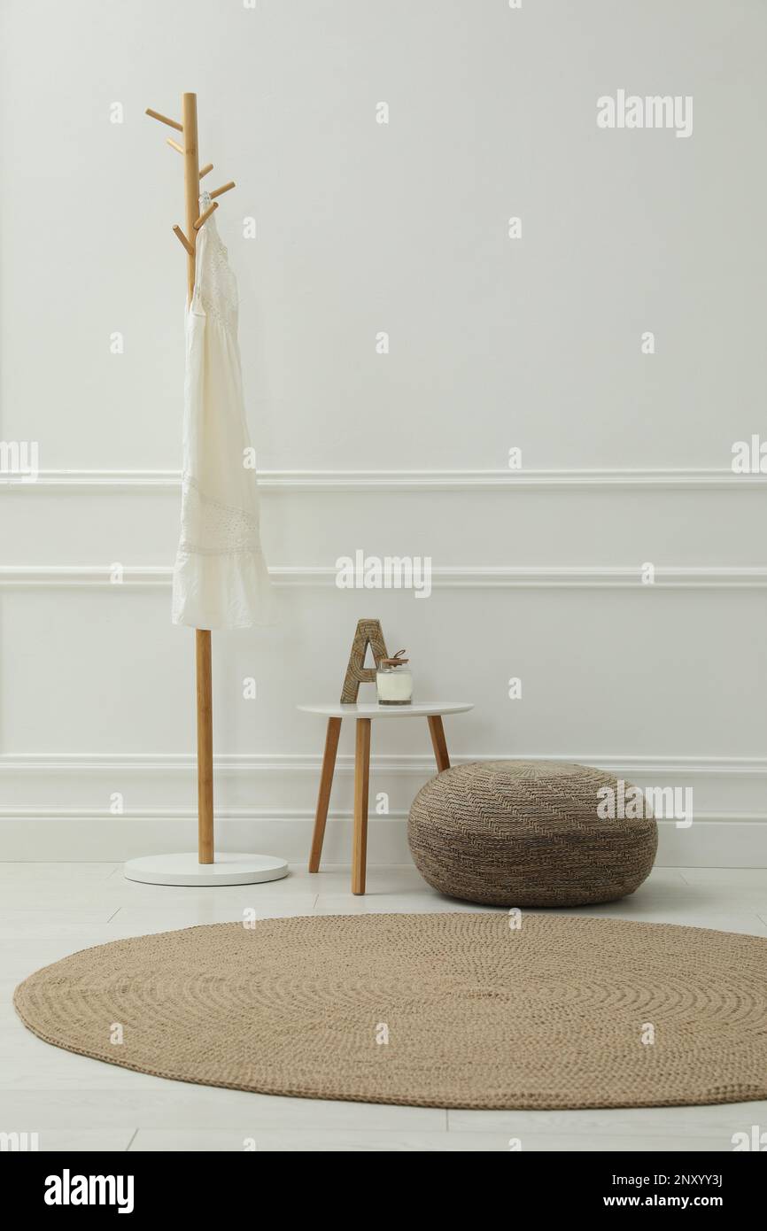 Simple hall interior with pouf, clothes rack and decor elements. Space ...
