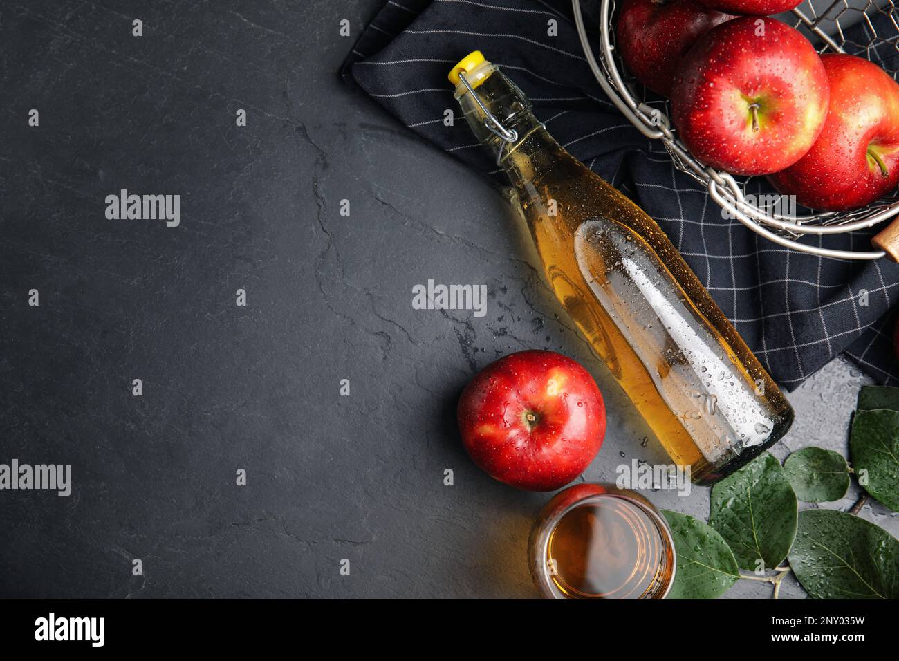 Flat lay composition with delicious apple cider on black table. Space ...