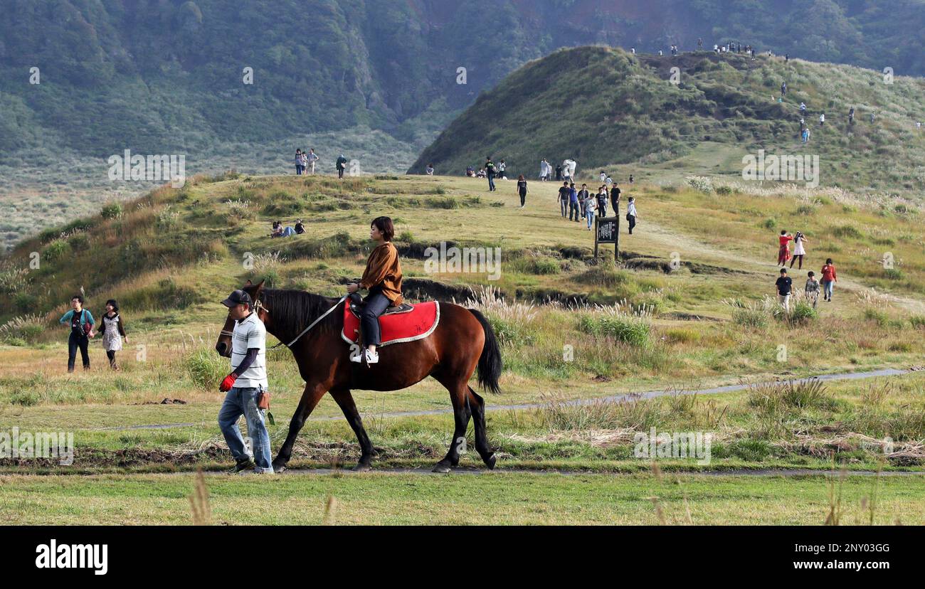 Visitors enjoy horse riding at Kusasenrigahara, Kusasenri Plateau in ...
