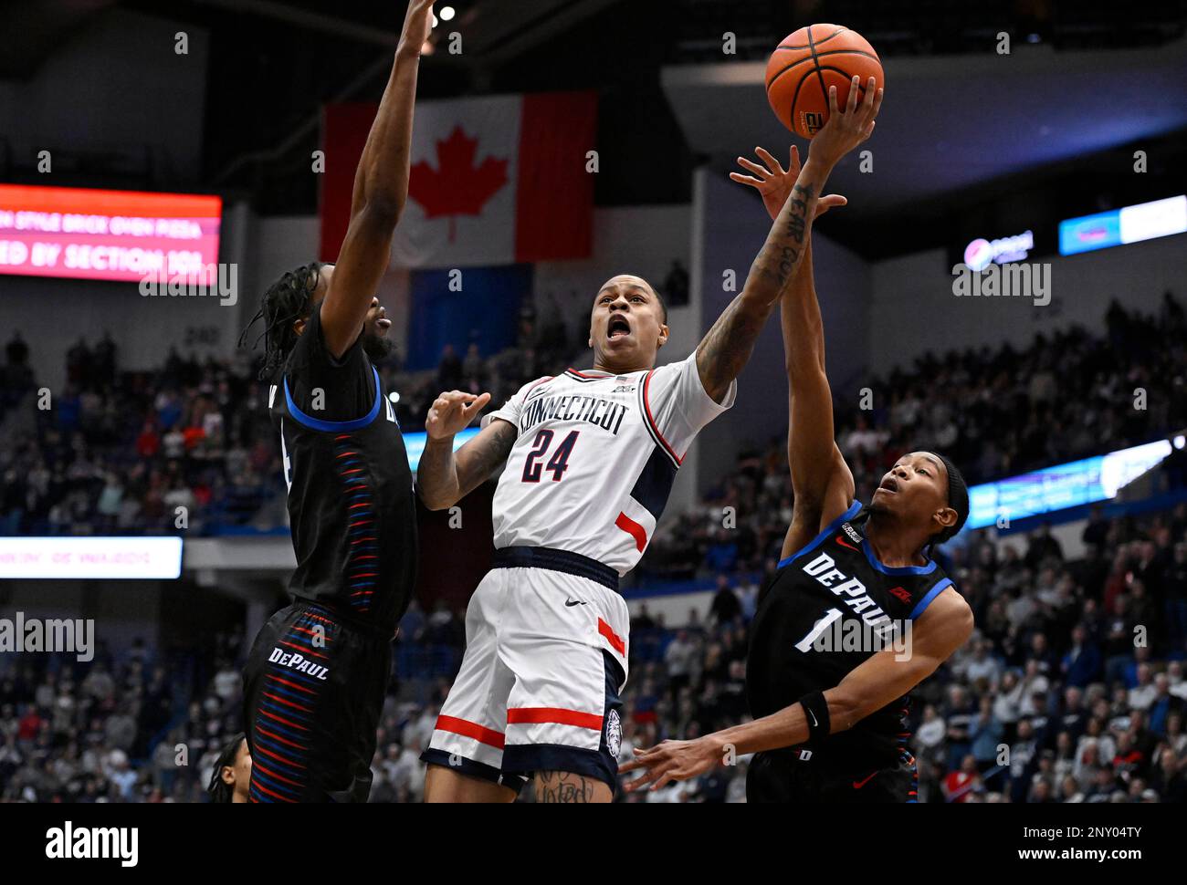 UConn's Jordan Hawkins shoots between DePaul's Nick Ongenda, left, and ...