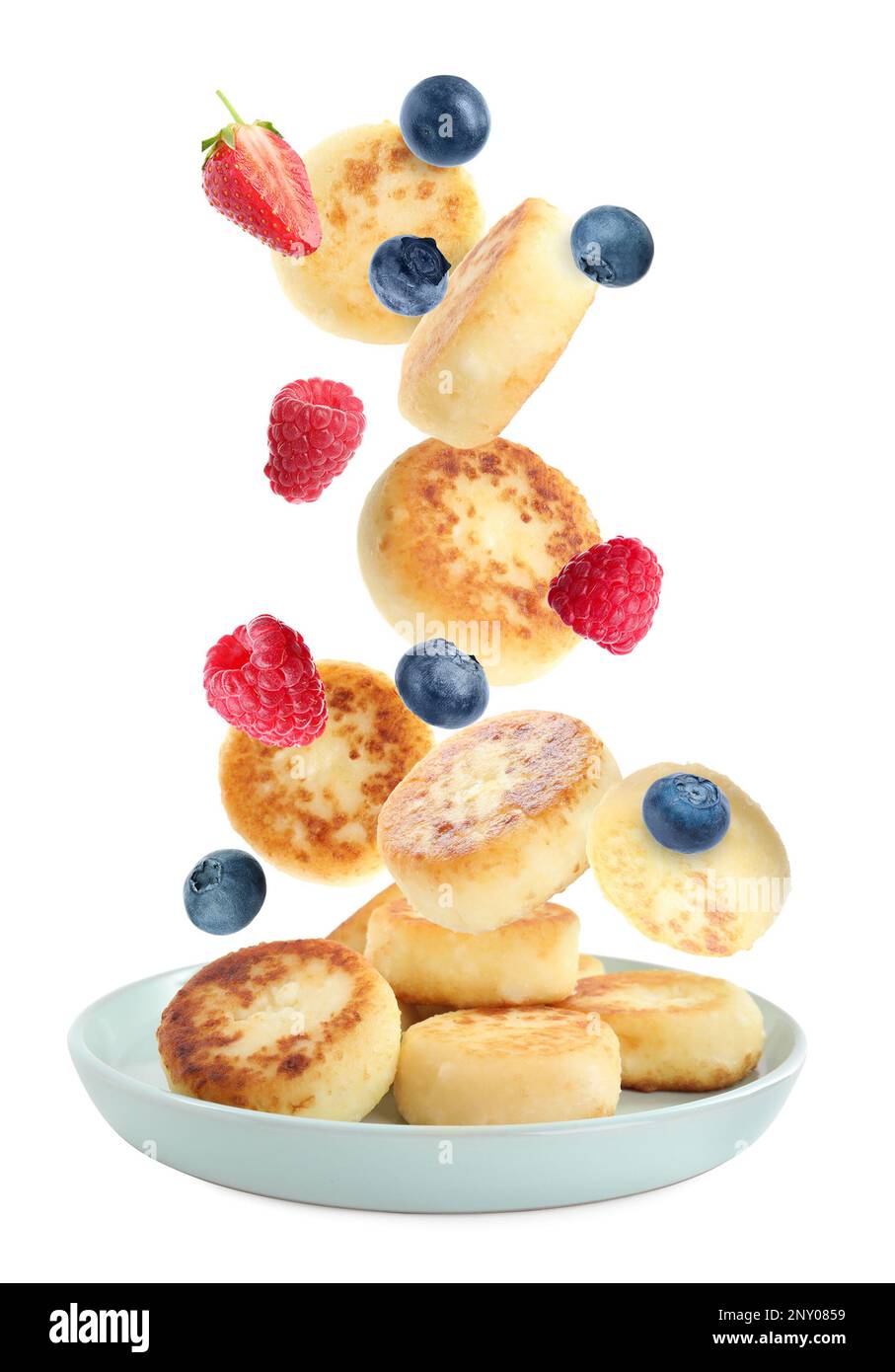 Delicious cottage cheese pancakes and berries falling into plate on ...