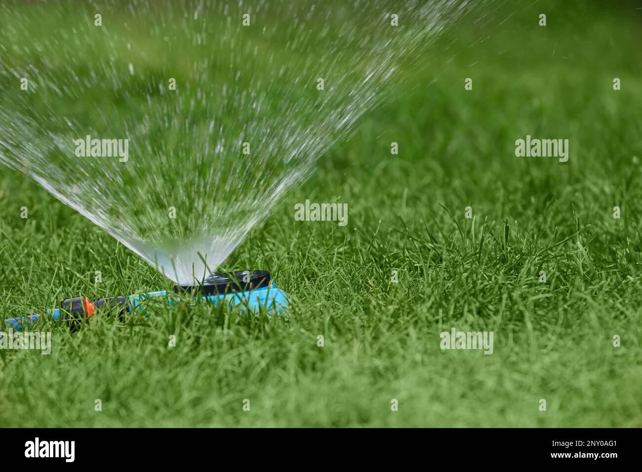 Automatic sprinkler watering green grass in park. Irrigation system ...