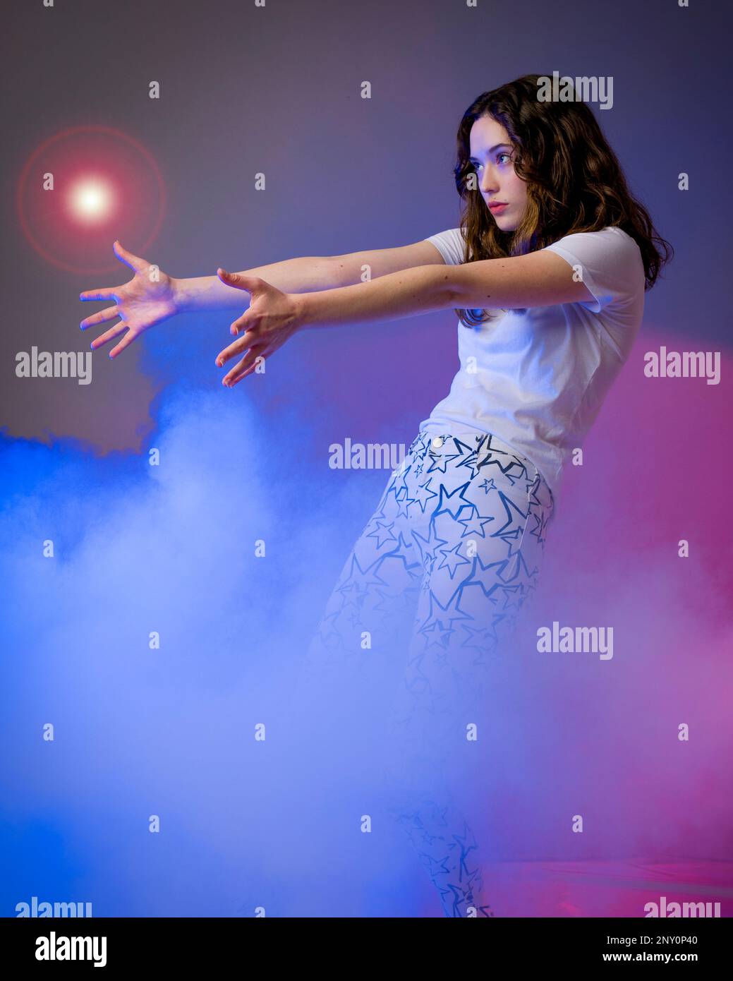 Teenage Girl Standing in Blue and Red Fog Performing Magic with Ball of ...