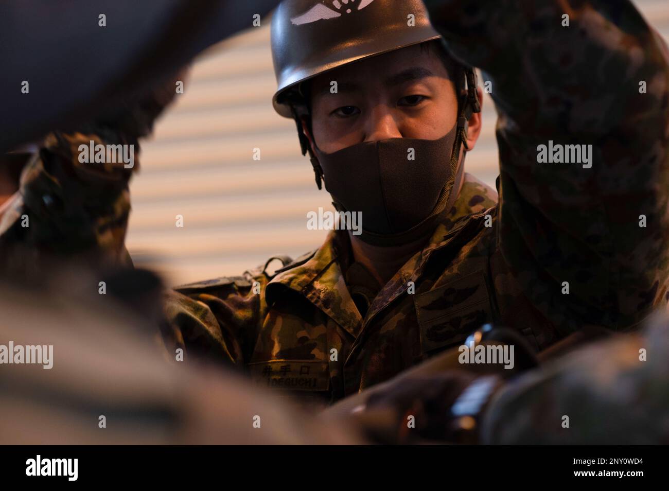 A soldier from the Japan Ground Self-Defense Force builds a bundle in ...