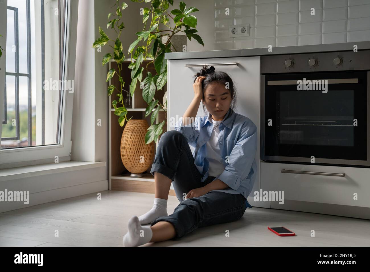 Upset depressed Asian girl suffering from breakup, waiting for call or ...