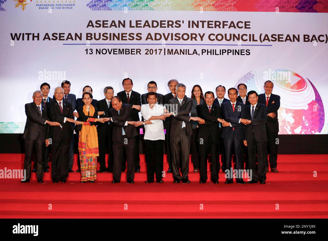 Philippine President Rodrigo Duterte, front center, links hands with ...