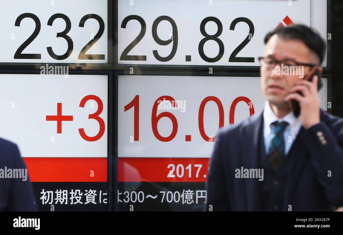 An electronic signboard shows Nikkei Stock Average topping 23,000yen at ...