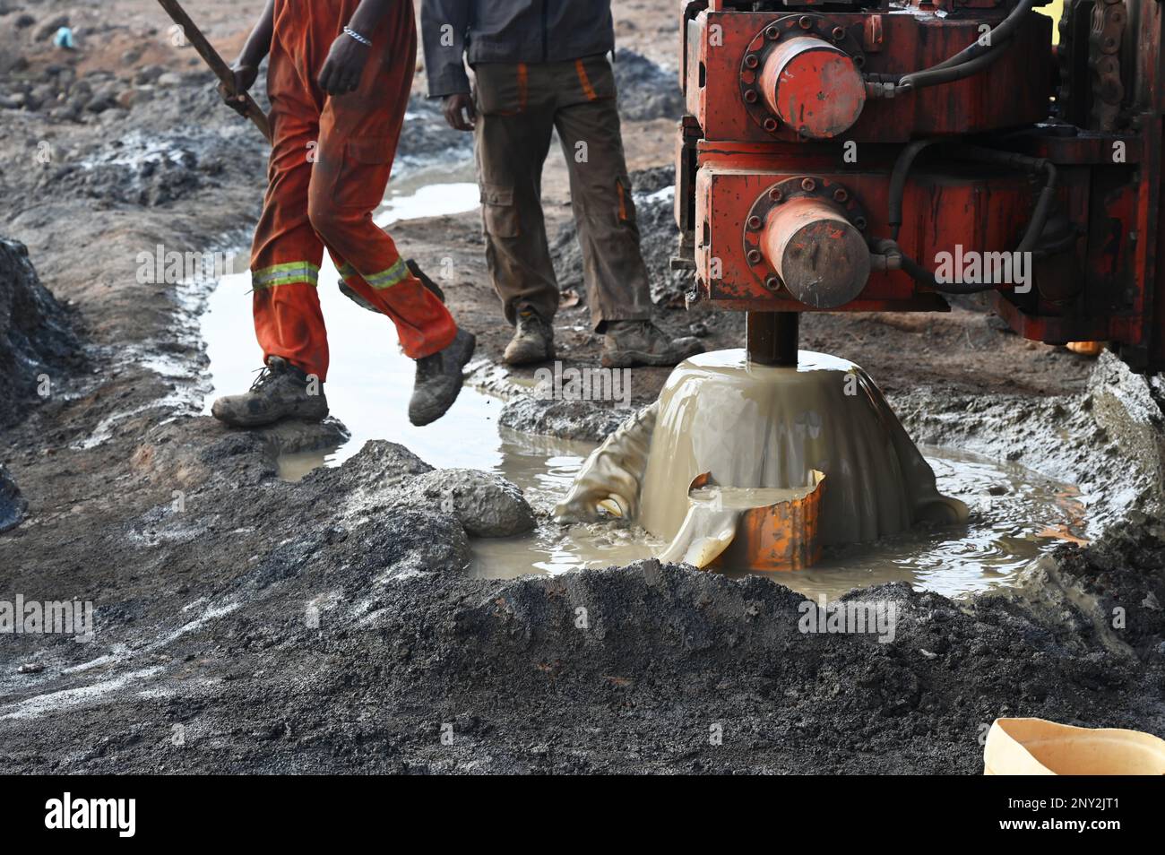 Local contractors work around and monitor well drilling operations ...