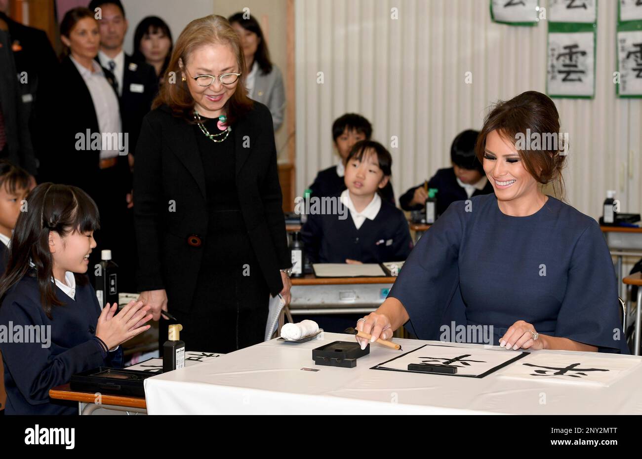 U.S. first lady Melania Trump finishes her calligraphy helped by a ...